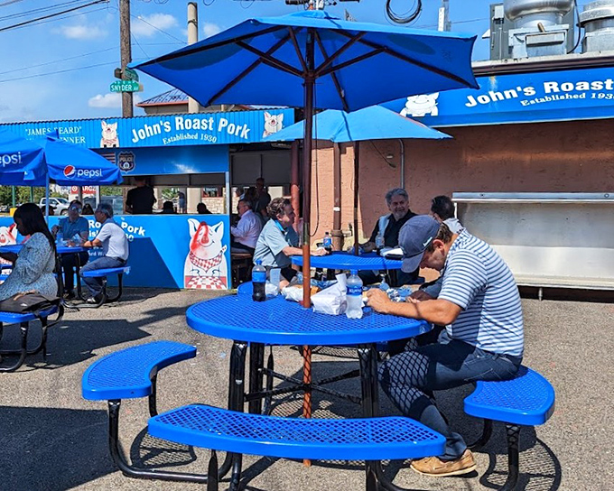 The outdoor seating area proves good things come to those who wait&mdash;blue umbrellas, picnic tables, and the promise of sandwich nirvana just steps away.