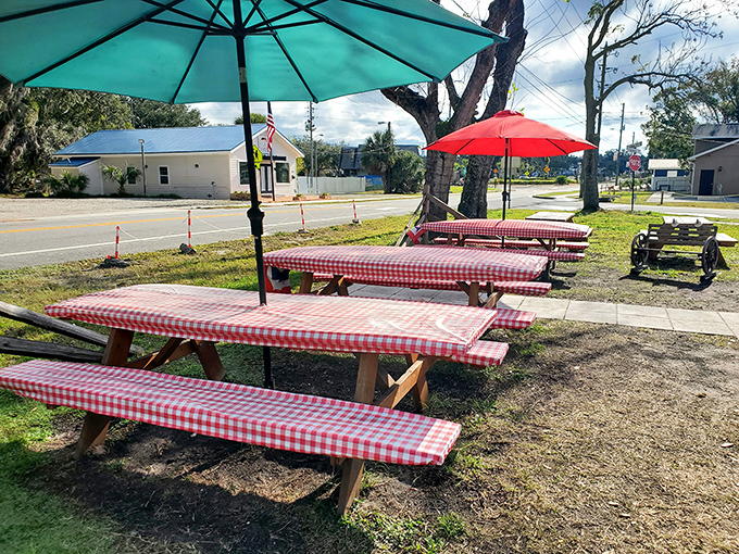 Red-checkered picnic tables under colorful umbrellas &ndash; the universal signal for "good times and great food happen here."