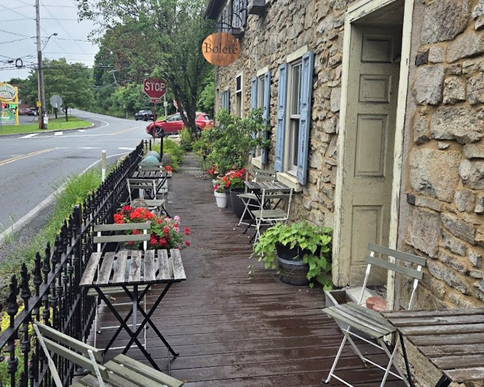 Al fresco dining at its most charming &ndash; where weathered wood, potted geraniums, and the promise of exceptional food create an irresistible sidewalk sanctuary.