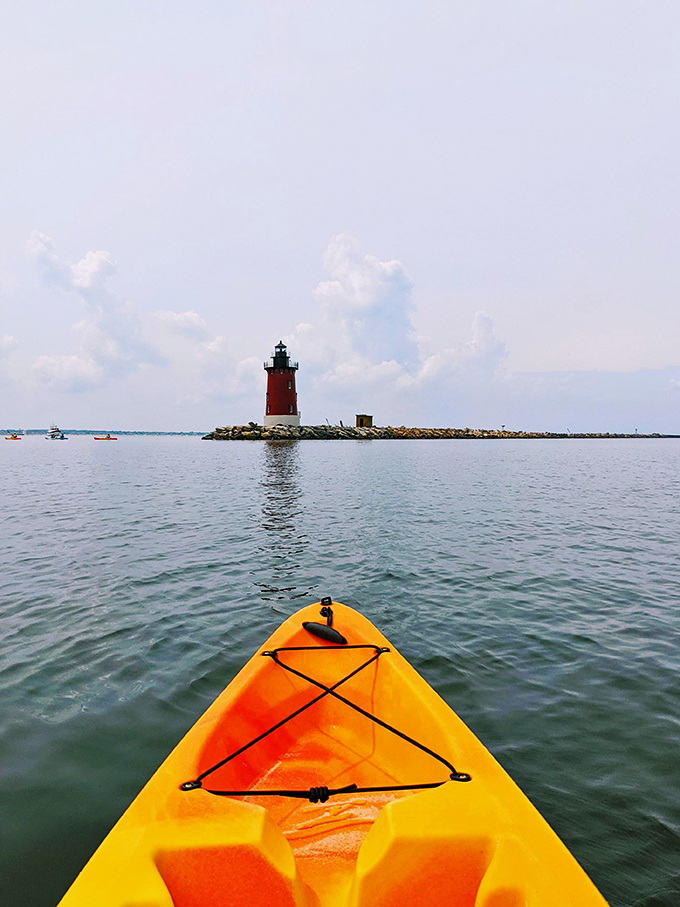 Kayaking toward the lighthouse feels like paddling into a postcard. That vibrant yellow vessel against the calm waters? Pure joy afloat.