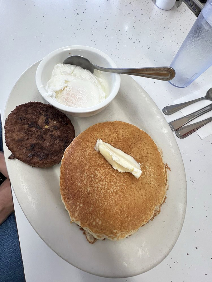 A pancake so perfectly golden it belongs in Fort Knox, paired with a sausage patty that's worth its weight in breakfast gold.