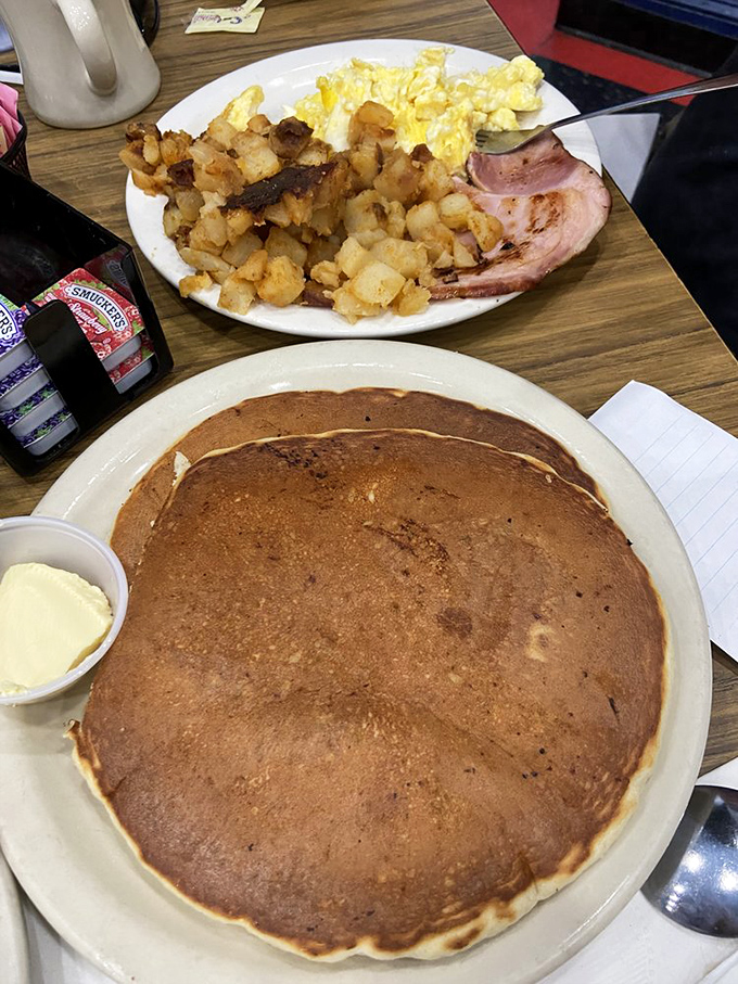 That pancake isn't just large&mdash;it's the size of a small frisbee, ready to soak up syrup like it's been training for this moment.