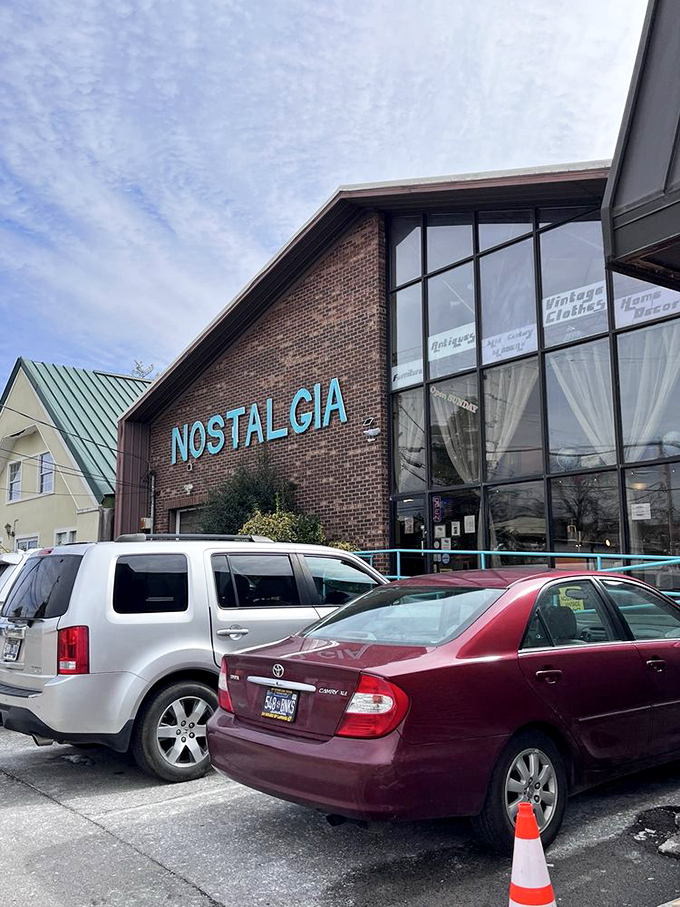 Even on cloudy days, Nostalgia's sign shines like a promise. Cars in the lot represent fellow explorers on the same quest.