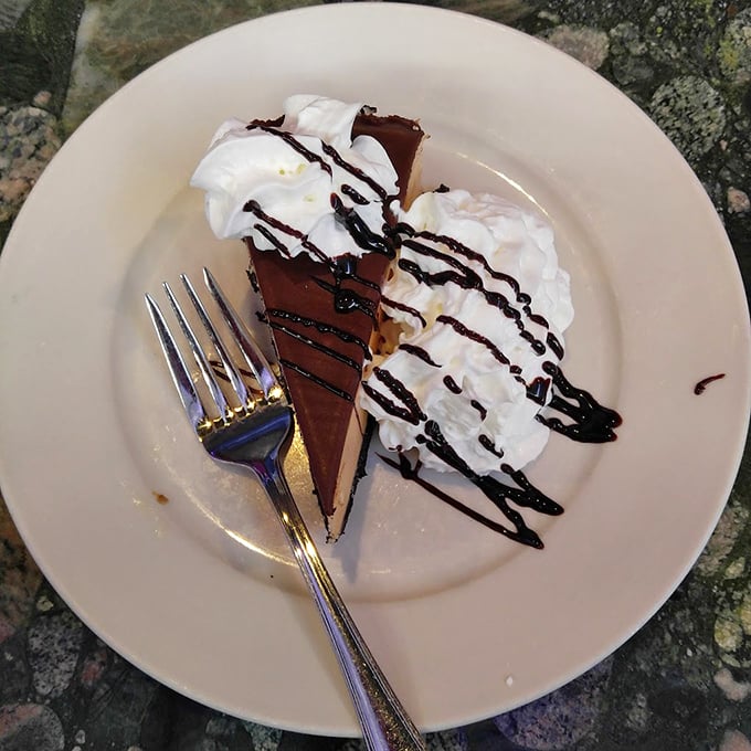 A slice of chocolate peanut butter pie that makes you wonder why you ever waste calories on lesser desserts. That whipped cream swirl is practically architectural.