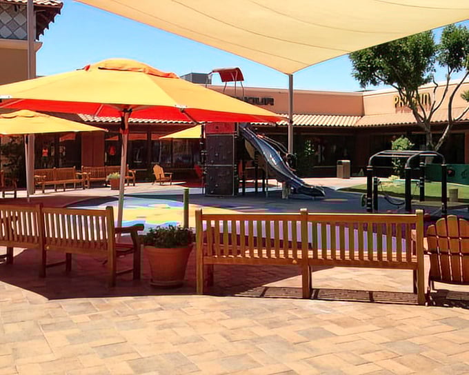 Colorful umbrellas and playground equipment create a family zone where shopping-weary children can burn energy while parents rest their credit cards.
