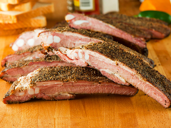 Pork ribs with a pepper-crusted exterior that gives way to tender, pink meat beneath. The kind of ribs that make you forget napkins exist.