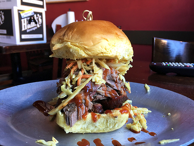 Not your average sandwich&mdash;this pulled pork masterpiece, crowned with slaw and sauce, demands both hands and your undivided attention.