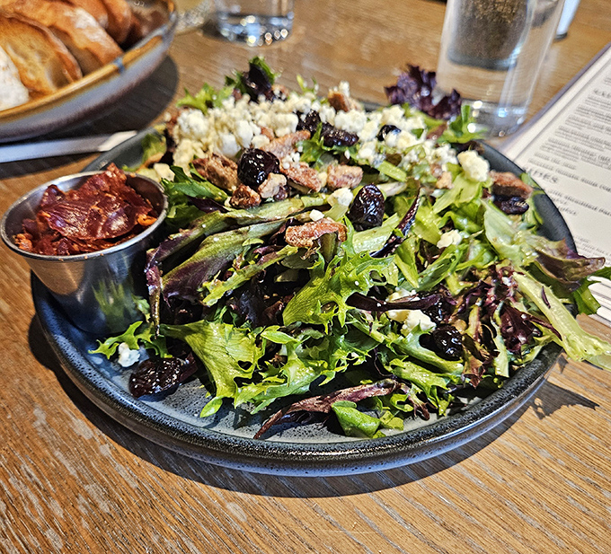 A salad that actually excites: fresh greens, crumbled cheese, and dried cherries creating a symphony that makes virtuous eating feel indulgent.