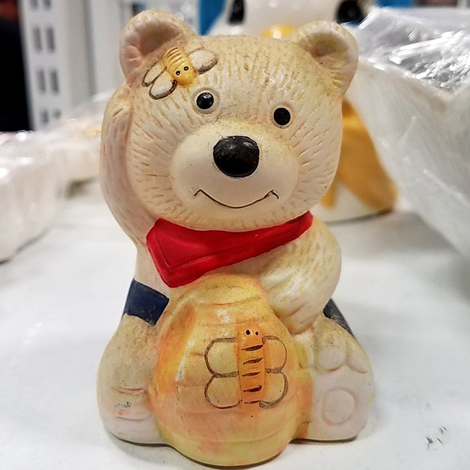 This cheerful bear figurine has seen things. Now he waits patiently for someone new to appreciate his honey pot and slightly unsettling smile.