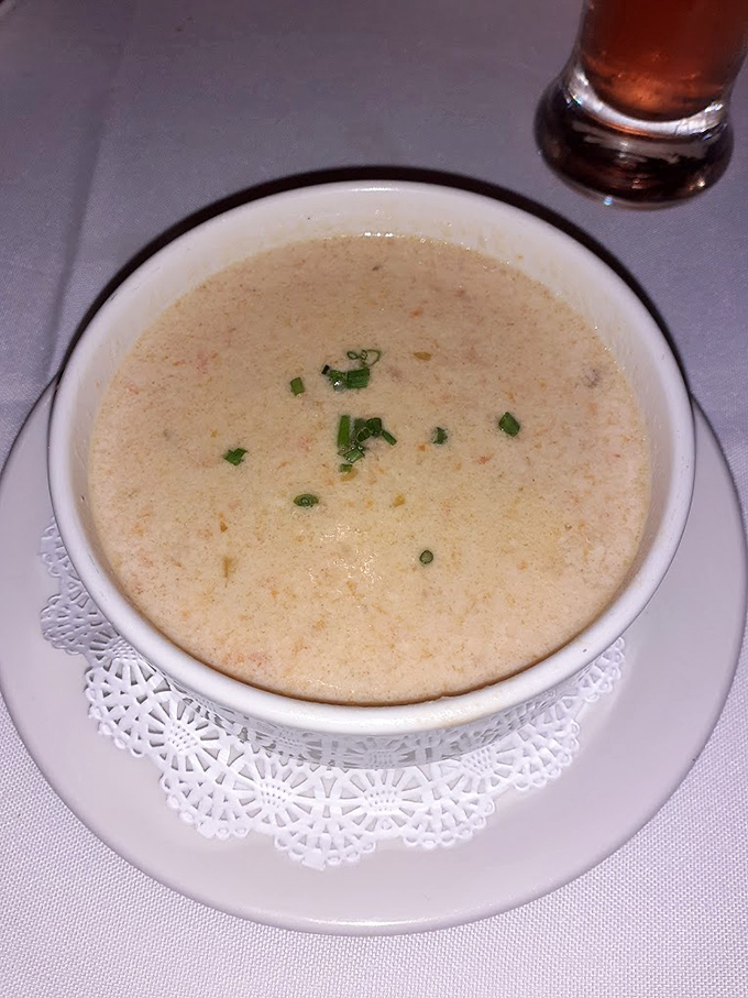 She-crab soup that's richer than most retirement portfolios&mdash;creamy, delicate, and garnished with just enough green to pretend it's not pure indulgence.