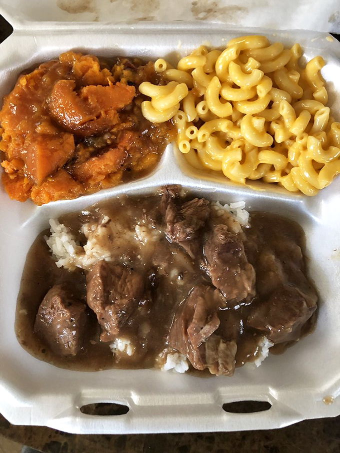 A holy trinity of Southern comfort: savory stewed beef, sweet candied yams, and mac & cheese that glows like edible sunshine.