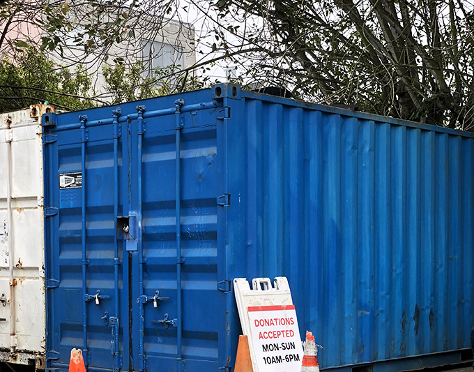 The blue donation container &ndash; where yesterday's impulse purchases become tomorrow's treasures in the great circle of retail life.