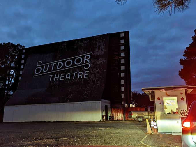 As dusk settles in, the illuminated ticket booth beckons moviegoers into a world where entertainment hasn't been complicated by technology.