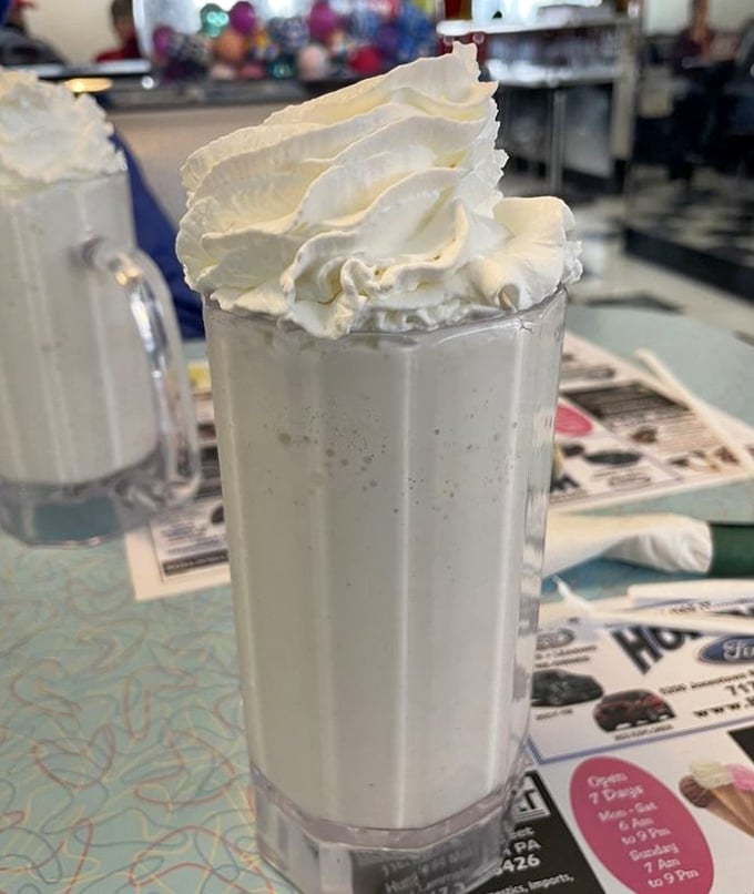 Vanilla milkshake perfection—thick enough to require serious straw strength but worth every bit of the effort. That whipped cream mountain deserves its own zip code.
