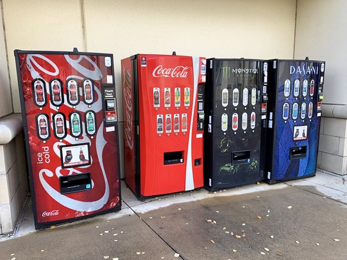 The vending machine lineup&mdash;silent sentinels offering liquid courage to continue the shopping marathon. That Coca-Cola machine has witnessed countless retail therapy sessions.