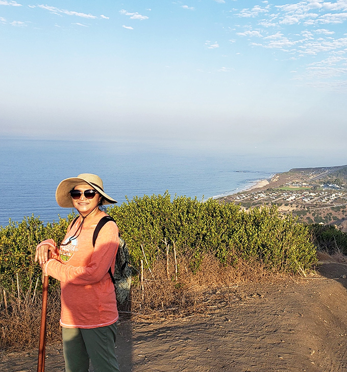 The universal hiking uniform: sun hat, walking stick, and that "I've discovered paradise" smile that comes free with the trail.