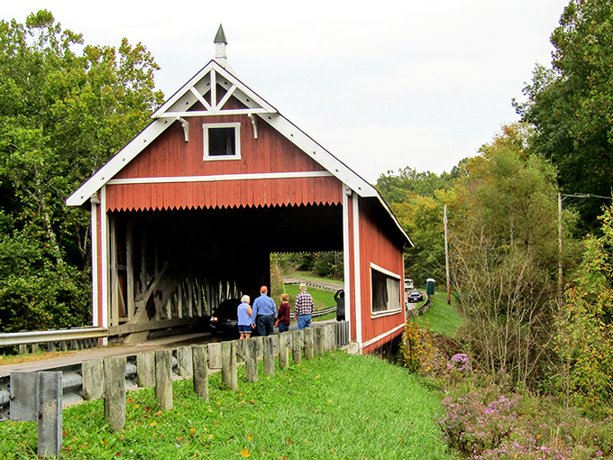 Visitors gather at the bridge's entrance, perhaps contemplating how many stories this wooden structure could tell if it could speak.