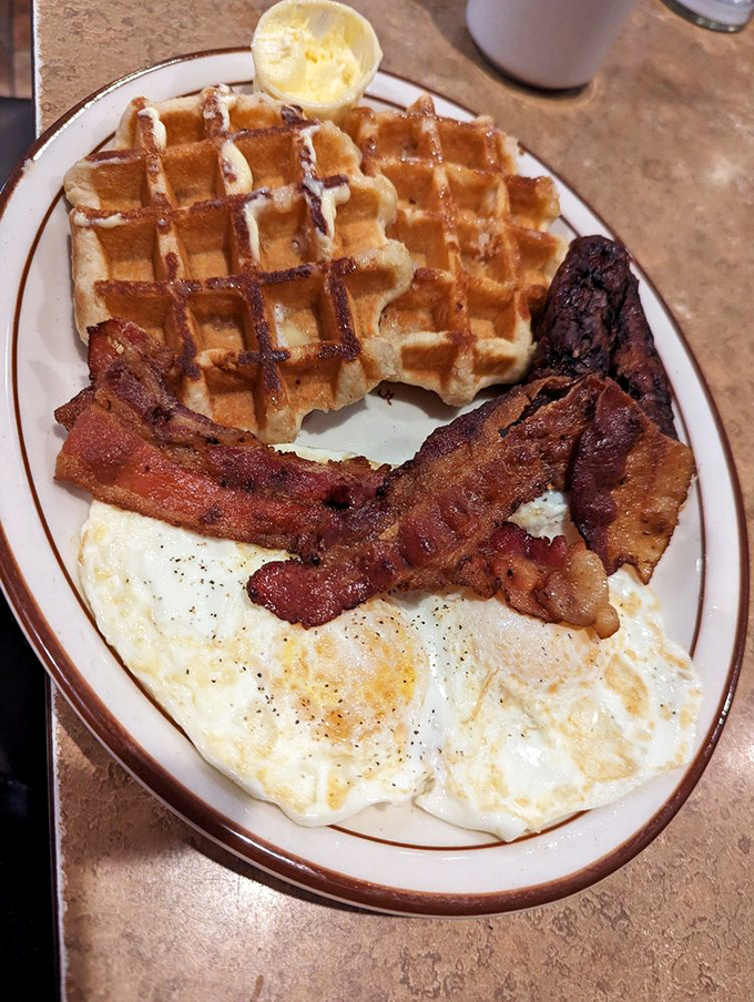 Waffles with perfect grid marks that could pass a geometry inspection. Paired with crispy bacon and eggs, it's the breakfast equivalent of winning the lottery.