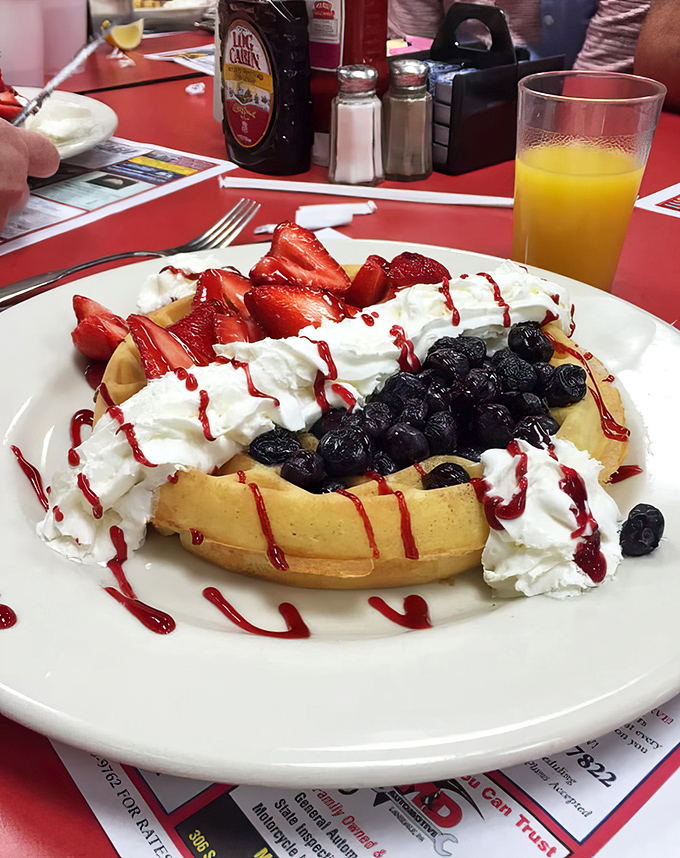 This waffle isn't just topped&mdash;it's celebrating. Berries, whipped cream, and drizzle creating a breakfast that's basically wearing party clothes.