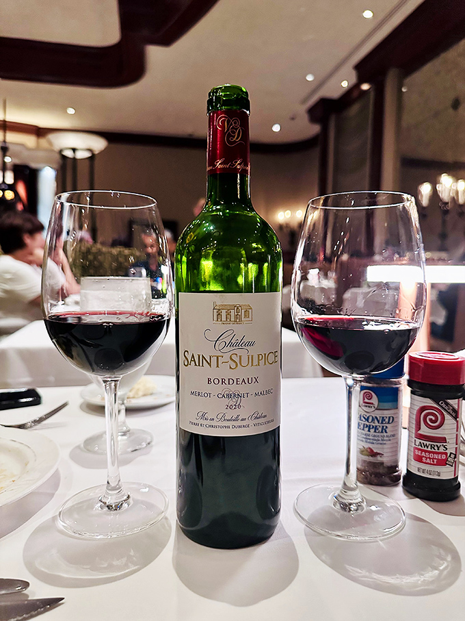 A bottle of Bordeaux standing at attention between two glasses&mdash;the liquid equivalent of a supporting actor who sometimes steals the show.