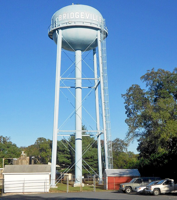 The iconic Bridgeville water tower stands tall against the blue sky, a landmark that welcomes residents home from their travels.
