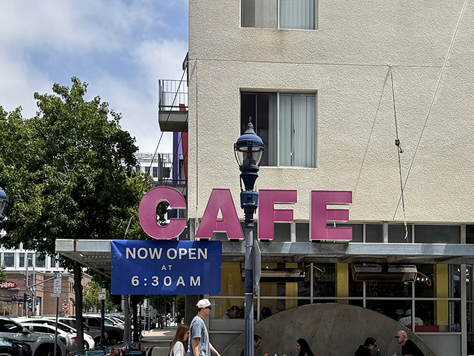 That bright pink "CAFE" sign is impossible to miss and promises breakfast adventures worth waking up early for.