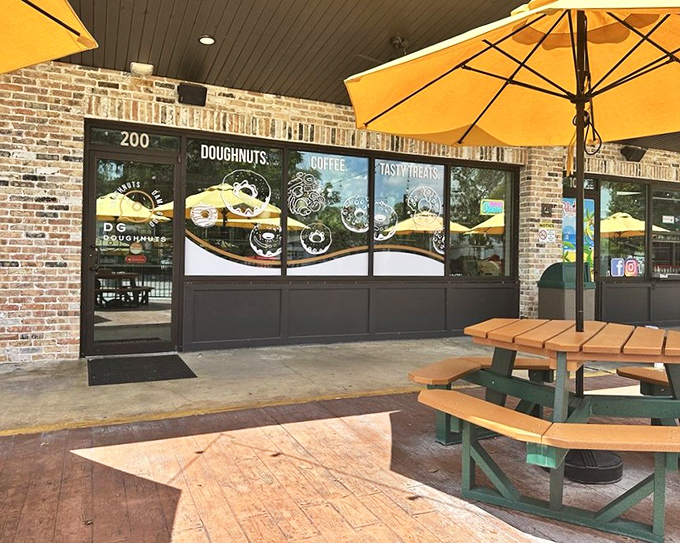 Brick walls and golden umbrellas create an upscale atmosphere where gourmet doughnuts meet caf&eacute; culture perfectly.