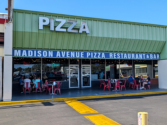 The bright green awning and vibrant red chairs promise a no-nonsense approach to seriously good pizza.