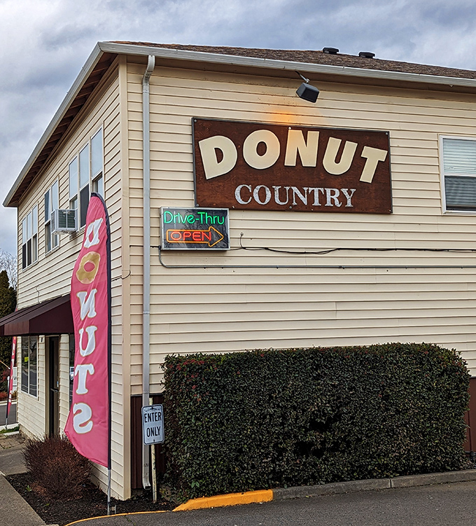 A pink "DONUT" flag flutters outside Donut Country's humble Medford location, like a sweet beacon calling to hungry travelers and locals alike.