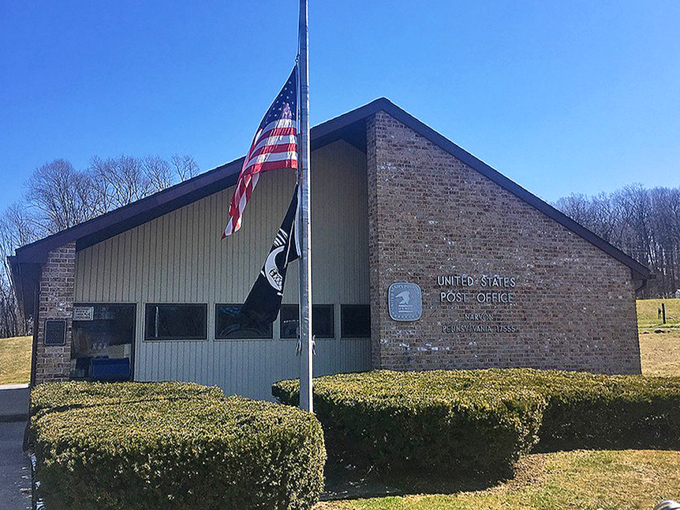 The American flag waves proudly over this modest post office, serving neighbors with old-fashioned personal care.