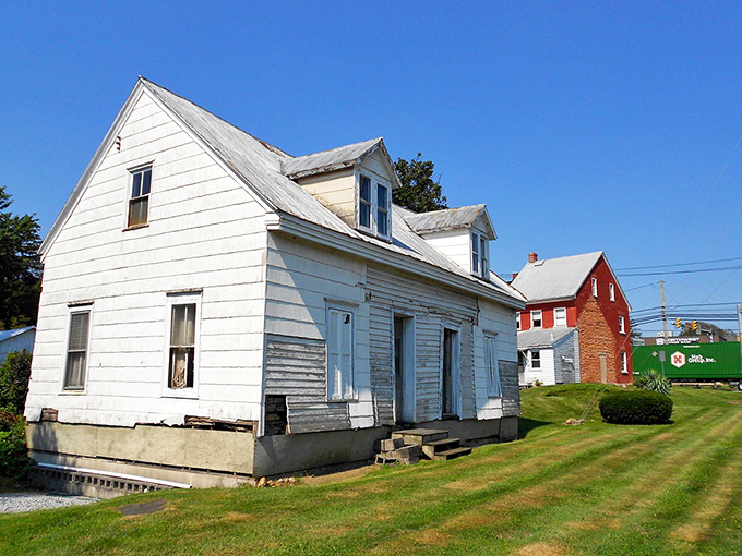 Simple white houses line the quiet street - where front porches still serve their original social purpose.