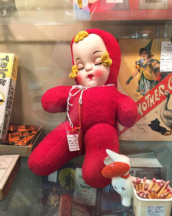 This sleeping beauty in cherry red chenille isn't just a doll&mdash;it's childhood comfort from an era before batteries required.