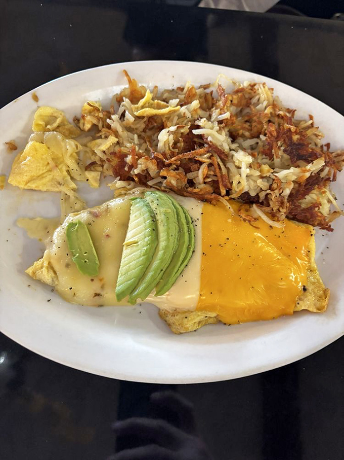 Breakfast artistry at its finest &ndash; a three-cheese omelet that stretches the definition of "portion control" in the most delicious way possible.
