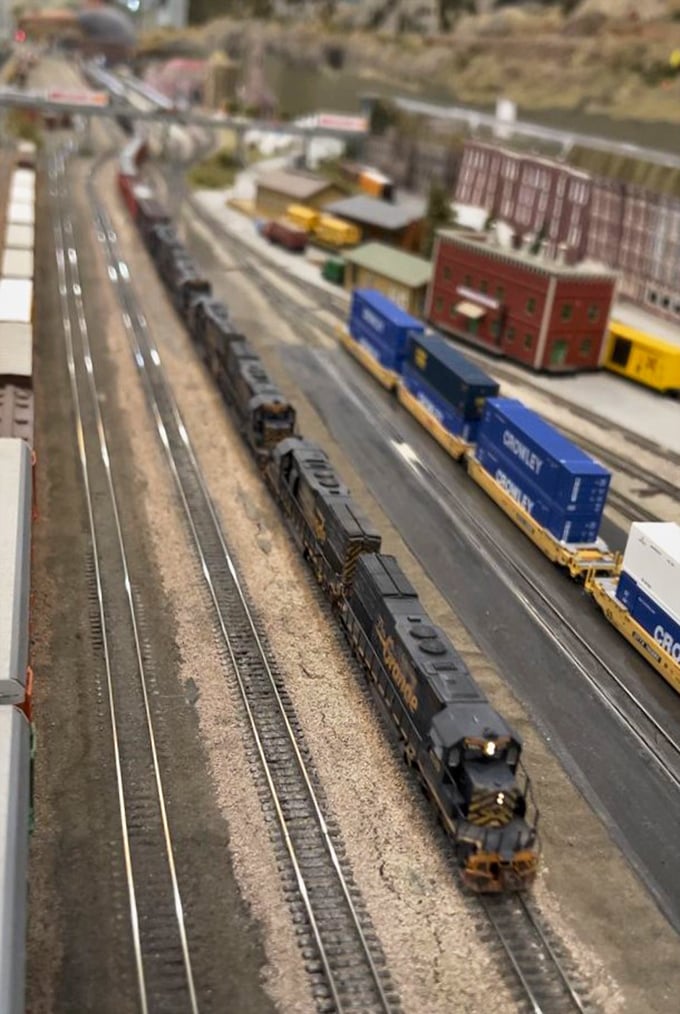 Freight trains snake through landscapes so realistic you'll forget you're looking at a tabletop universe.