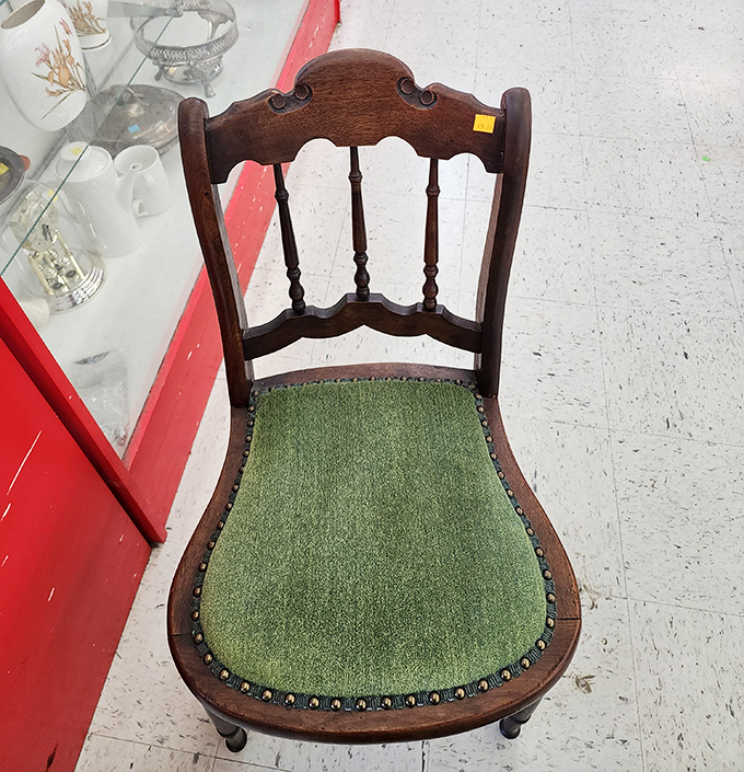 The vintage chair with green upholstery whispers tales of dinner parties past while offering surprisingly comfortable seating for future gatherings.