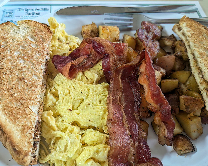 The holy trinity of breakfast: perfectly scrambled eggs, bacon with just the right crisp-to-chew ratio, and toast waiting to soak up every last bit.