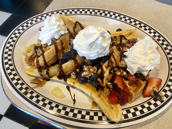 This waffle dessert situation is what happens when breakfast decides to live its best life – whipped cream mountains, fruit valleys, and chocolate rivers.