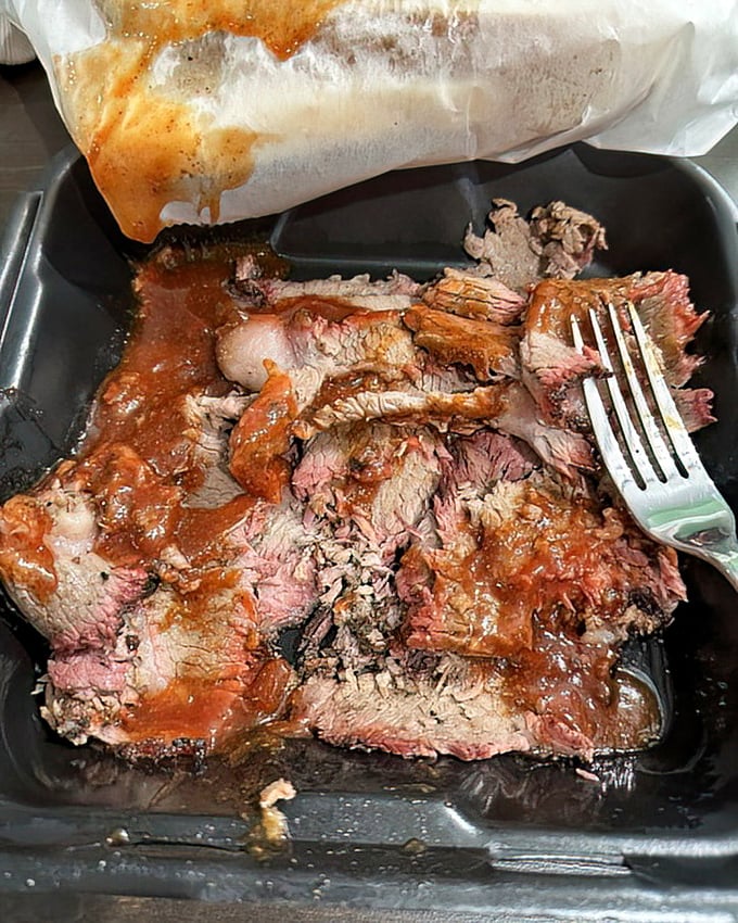 Brisket with that telltale pink smoke ring&mdash;nature's way of saying "this was done right." The fork is merely a suggestion.