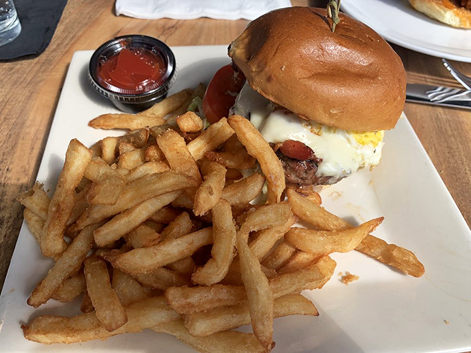 A burger that requires both hands and a strategy &ndash; crispy fries standing at attention beside a sandwich that's more monument than meal. 