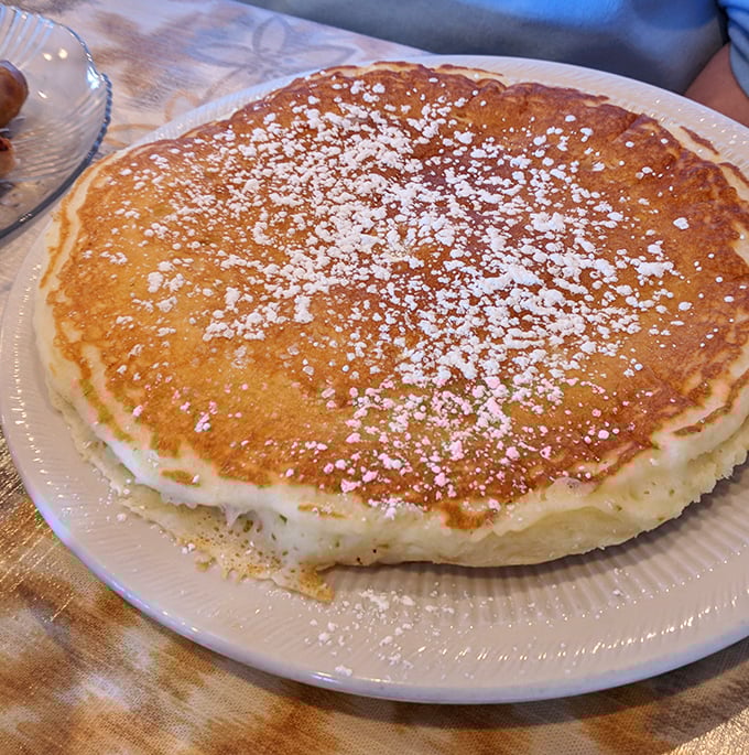 This pancake isn't just large&mdash;it's territorially ambitious. The powdered sugar snowfall adds that touch of sweetness that makes mornings worthwhile.