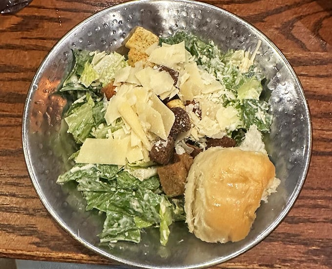 A Caesar salad that Julius himself would approve of, complete with a dinner roll that's clearly been working out at the bread gym.