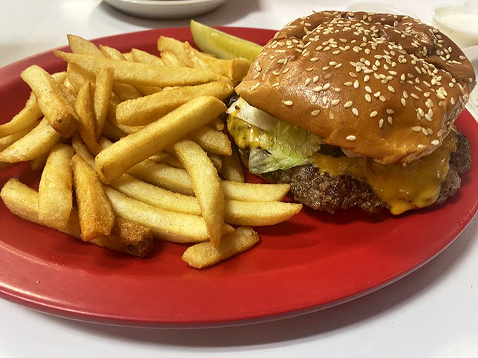 The cheeseburger in its natural habitat&mdash;surrounded by golden fries on a red plate. A timeless American romance.