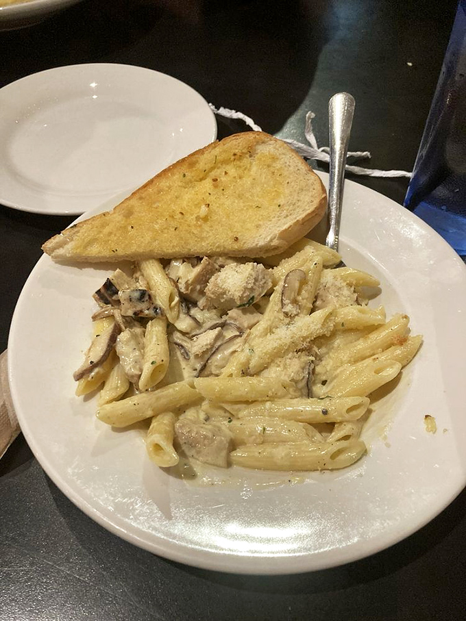 Pasta that doesn't just sit on the plate but lounges luxuriously in creamy sauce, with that garlic bread standing by for the inevitable sauce-sopping finale.