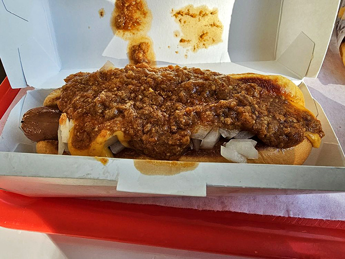The chili dog in its natural habitat&mdash;nestled in a paper boat, surrounded by fries, waiting to transform your ordinary lunch into a moment of pure joy.