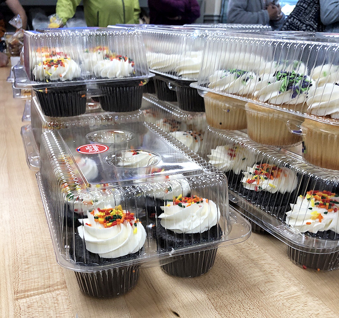 Cupcakes in their natural habitat—plastic containers that can barely contain the joy of perfectly swirled frosting topped with a confetti party.