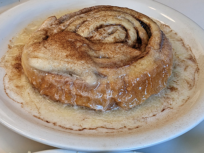 A cinnamon roll so generous it needs its own zip code, glazed and ready for sweet surrender.