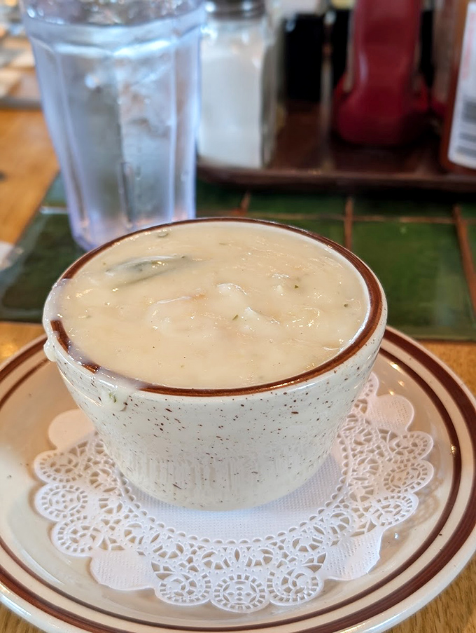 A cup of clam chowder served on a doily&mdash;because even comfort food deserves a touch of elegance on the Oregon coast.