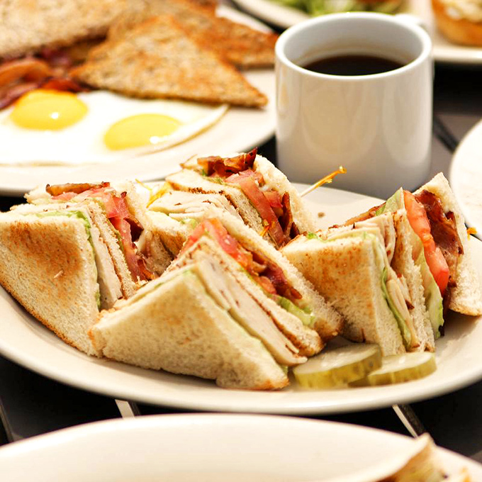 The club sandwich&mdash;an engineering marvel of bread, meat, and vegetables that requires both hands and a strategy. Worth every bite.