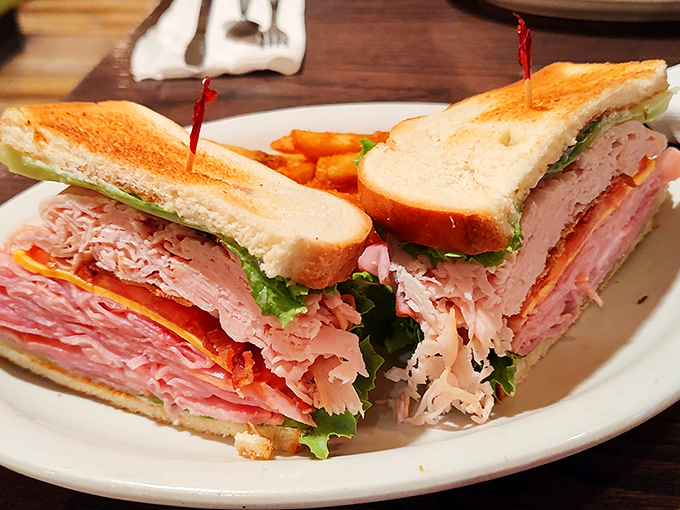 This club sandwich stands tall and proud, layers of deli meats and fresh vegetables creating the skyscraper of sandwiches that requires strategic bite planning.