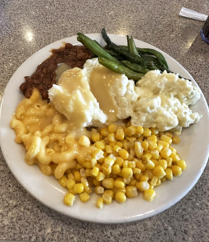 Comfort food's greatest hits album on a single plate&mdash;creamy mac and cheese, mashed potatoes with gravy, and vegetables pretending to make it healthy.